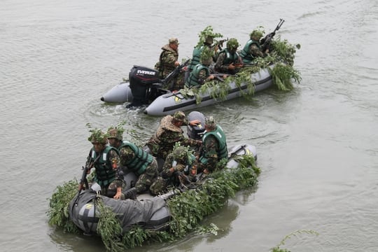Well-camouflaged Romanian troops load into high-speed rafts within ...